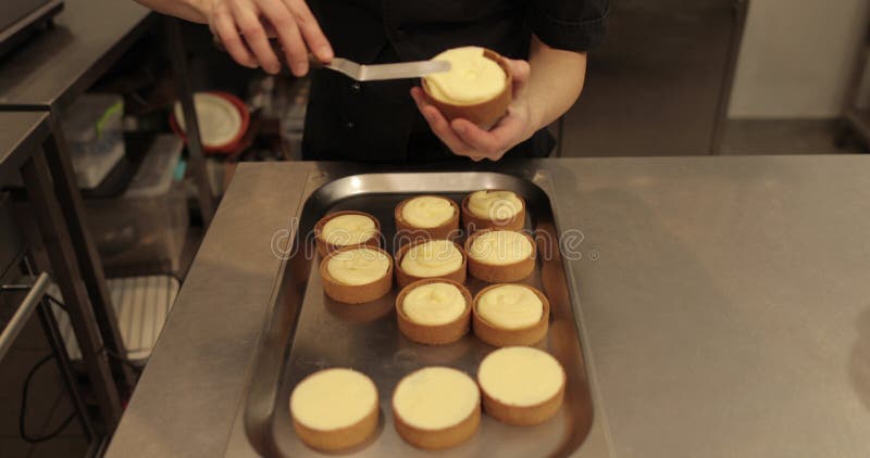 The Hands of a Pastry Chef in a Red Apron Holding a Sponge Cake Stock ...