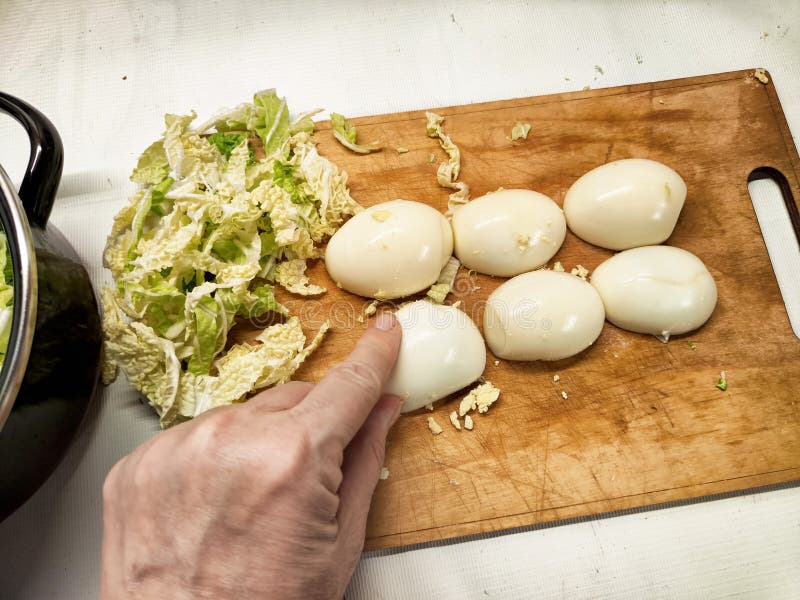 Preparing Boiled Eggs and Sliced Cabbage on a Wooden Cutting Board in a ...