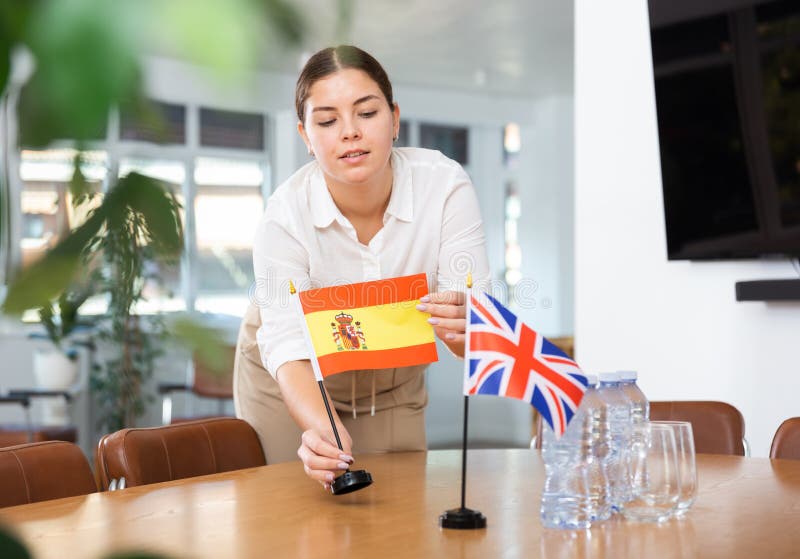 Preparing for Business Presentation - Secretary Places Flags of Spain ...