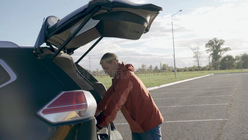 The Driver Puts Things in Order in the Trunk of the Car. Stock Footage ...