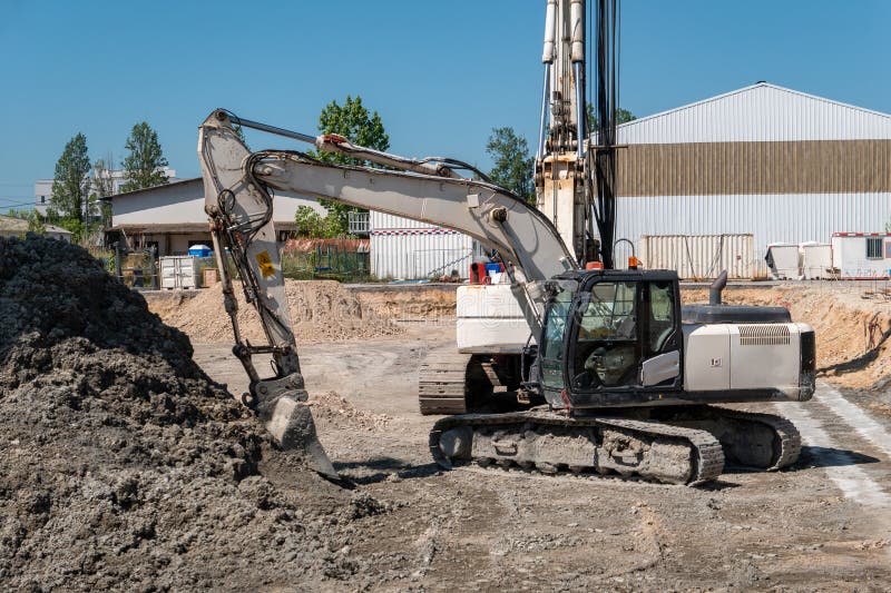 Preparing the Ground: Backhoe in Action at the Construction Site for ...
