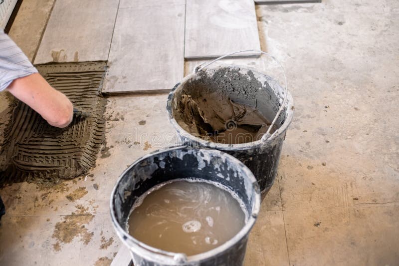 Preparing Tile Adhesive in Buckets during a Flooring Renovation Project ...