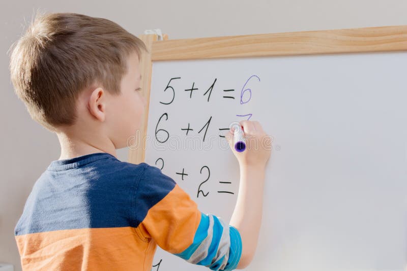 A Preschool Boy Writes the Answer To a Math Example on a White Board ...