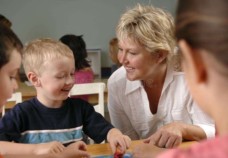 Adult Helping Two Young Children at Montessori/Pre Stock Photo - Image ...