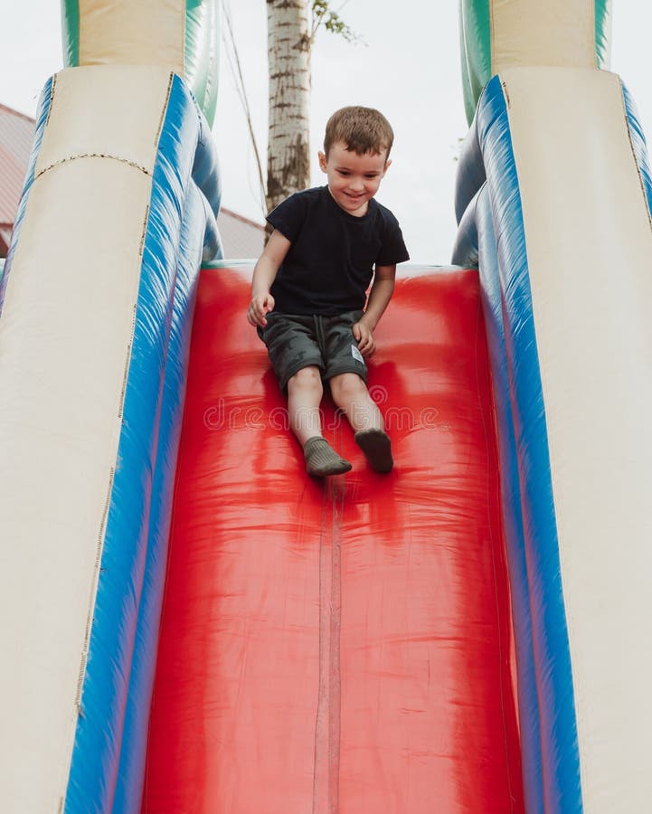 Preschooler Boy Slides Down a Slide on Trampoline Stock Image - Image ...