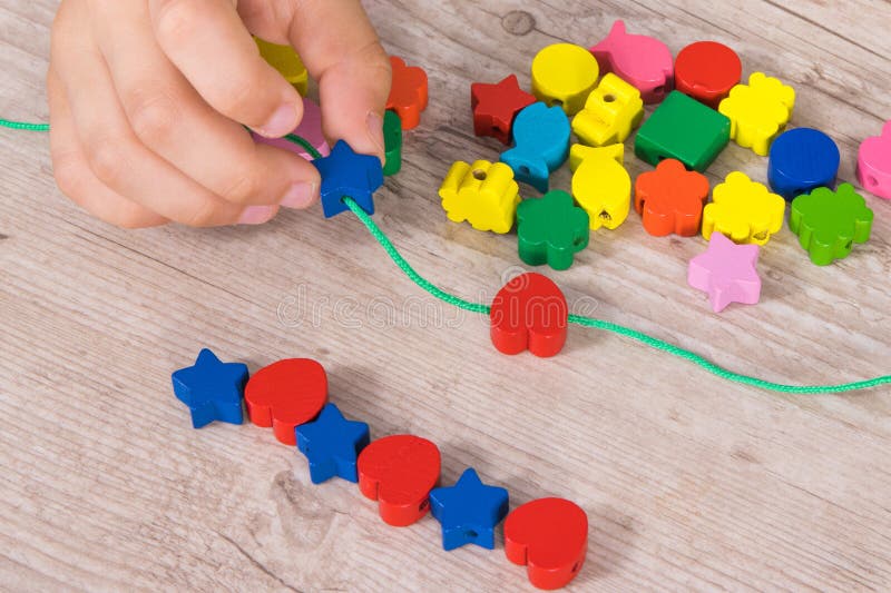 Preschooler Making Bracelet from Thread and Colored Beads. Development ...