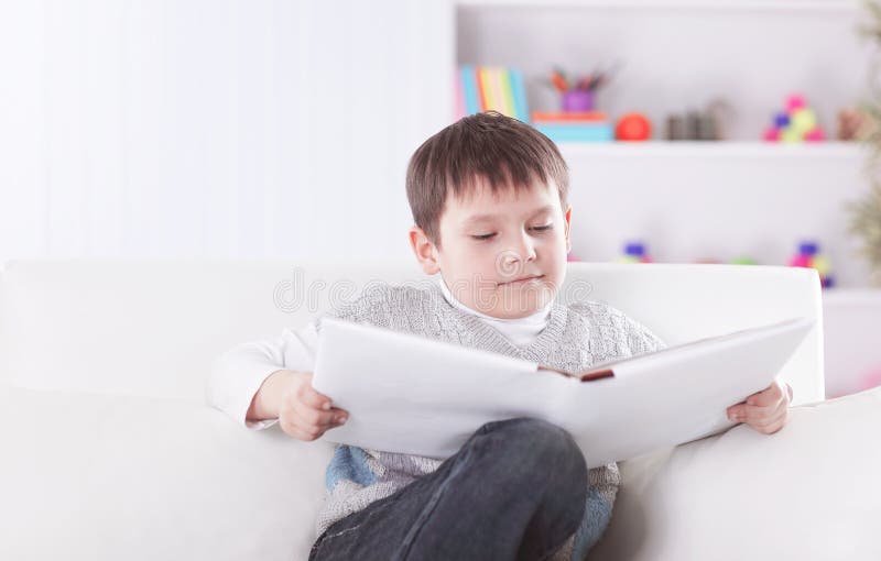 Preschooler Reading a Book on the Couch in the Nursery Stock Image ...