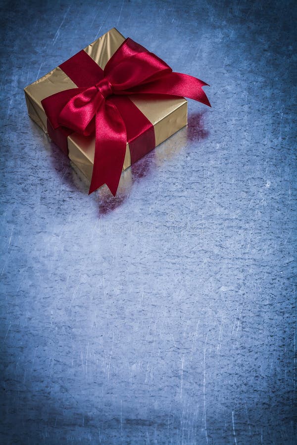 Present Box Wrapped in Shining Golden Paper on Metallic Surface Stock ...