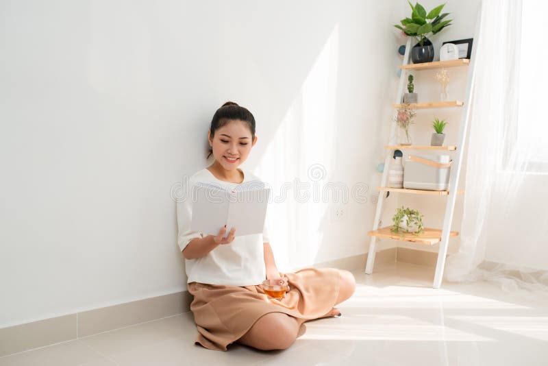 Pretty Asian Woman Drinking Tea and Reading Book at Home Stock Photo ...