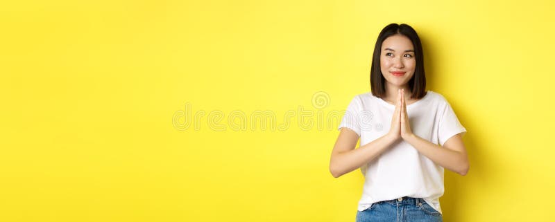 Pretty Asian Woman Holding Hands In Namaste Pray Gesture Looking Left