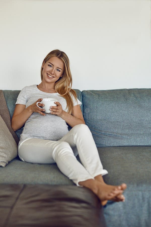Pretty Barefoot Young Pregnant Woman Relaxing On A Couch Stock Image