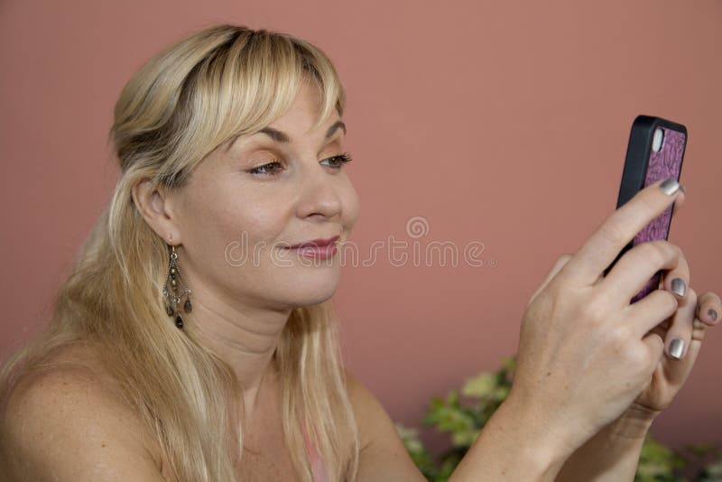 A Pretty Blond Woman Texting on Her Pink Cell Phone Stock Image - Image ...