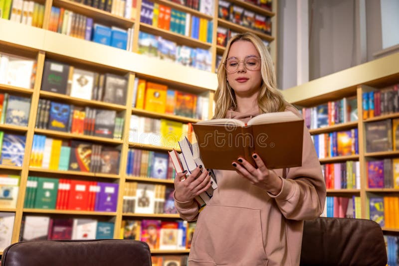 Pretty Blonde Woman Standing with Books in Library Stock Photo - Image ...