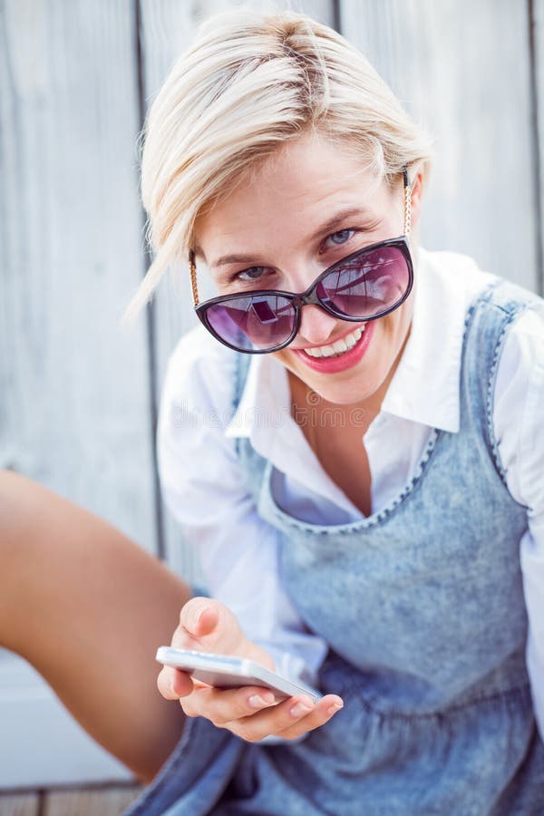 Pretty Blonde Woman Wearing Sun Glasses And Texting With Her Mobile