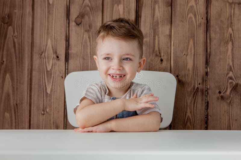 A Pretty Boy is Sitting at the Table. Close-up Stock Photo - Image of ...