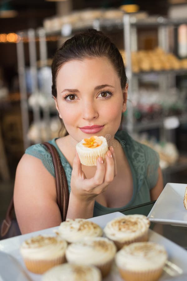 Pretty Brunette Smelling a Cupcake Stock Image - Image of cafeteria ...