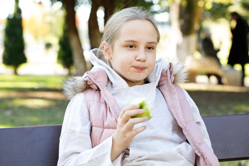 Pretty Child Eating Apple Fruit Outdoors. Young Girl 10 Years Old Stock ...