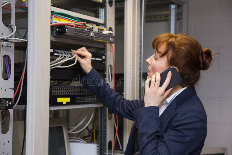 Pretty Computer Technician Talking on Phone while Fixing Server Stock ...