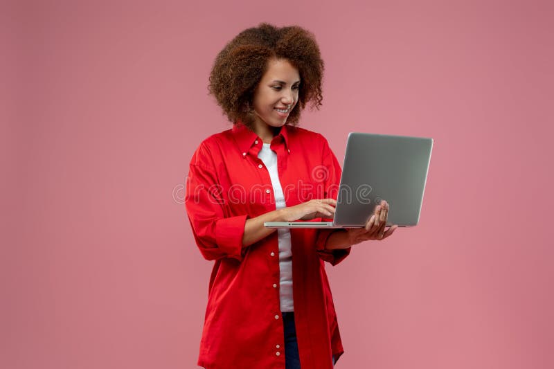 Pretty Curly-haired Woman in Red Jacket Working on Laptop Stock Image ...