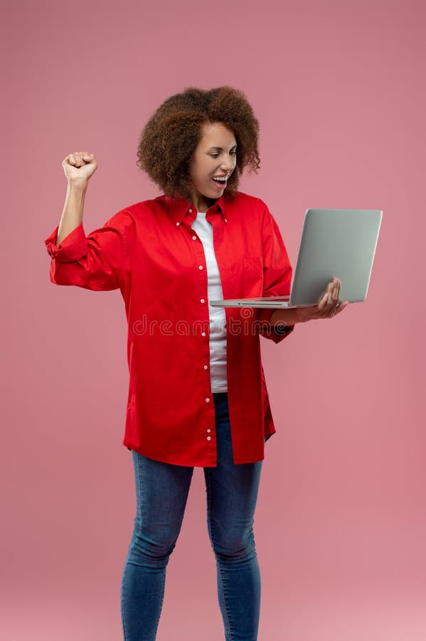 Pretty Curly-haired Woman in Red Jacket Working on Laptop Stock Image ...