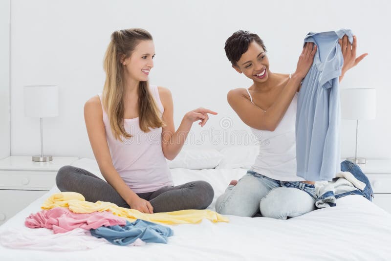 Pretty Female Friends Selecting Clothes in Bed Stock Image - Image of ...