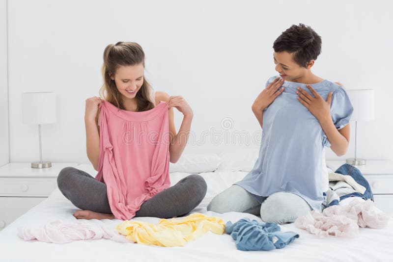 Pretty Female Friends Selecting Clothes in Bed Stock Photo - Image of ...