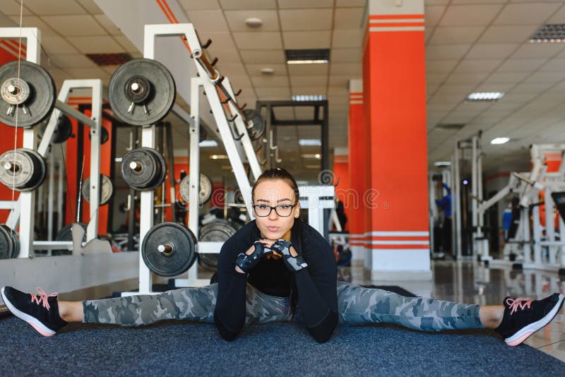 Pretty Girl Doing Stretching Exercises on the Floor at the Gym. Stock ...