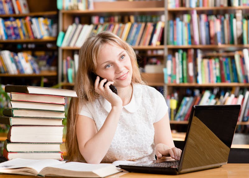 Pretty Girl in Library Typing on Laptop and Talking on the Phone Stock ...