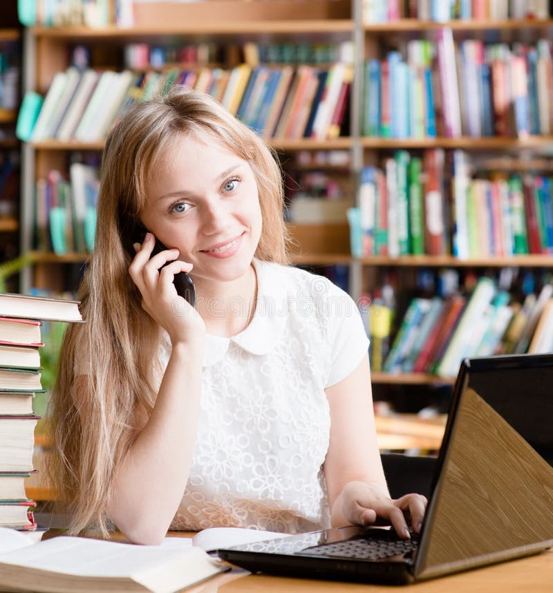 Pretty Girl in Library Typing on Laptop and Talking on the Phone Stock ...