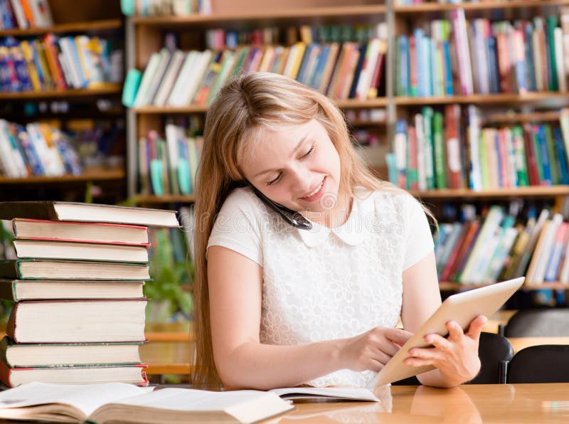Pretty Girl in Library Using Tablet Computer and Talking on the Phone ...