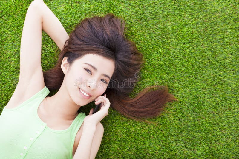 Pretty Girl Lying Down on a Meadow and Talking by Smartphone Stock ...