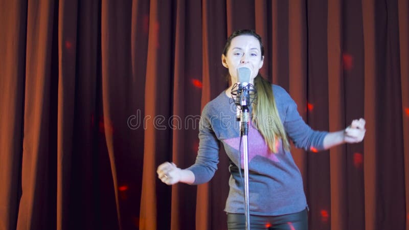 Pretty Girl Singing on a Stage at a Party with Lights on Background ...