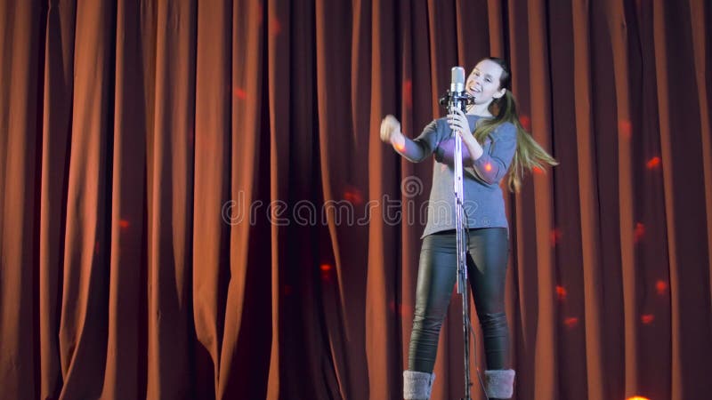 Pretty Girl Singing on a Stage at a Party with Lights on Background ...