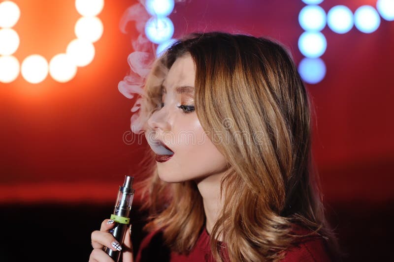 Pretty Girl Viper Smoke E-cigarette in a Nightclub. Stock Image - Image ...