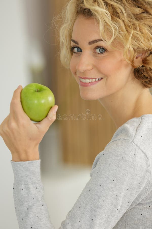 Pretty lady holding apple stock photo. Image of smile - 194270342