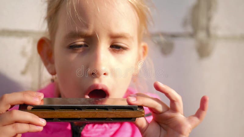 Pretty Little Girl Playing Harmonica in Outdoors. Stock Video - Video ...