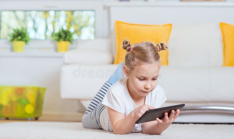 Pretty Little Girl Using a Digital Tablet, Looking and Smiling Stock ...
