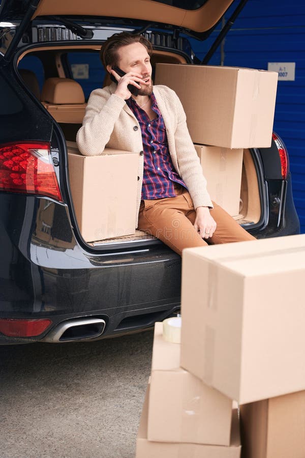 Young Guy with Cardboard Boxes in Car Trunk at Storage Warehouse Stock ...