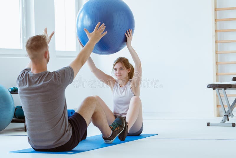Pretty Patient on the Blue Mat in the Gym and Training with the Ball ...