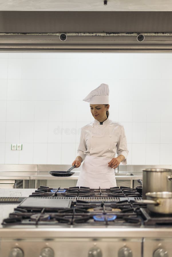 Pretty Professional Chef Cooking in a Kitchen. Stock Image - Image of ...