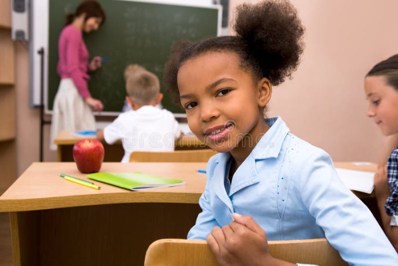 High School Tutor Sitting at Desk with Female Student in Biology Class ...