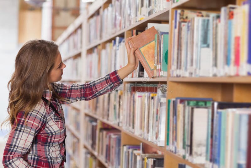 Pretty Student Placing Book in Shelf Stock Photo - Image of research ...