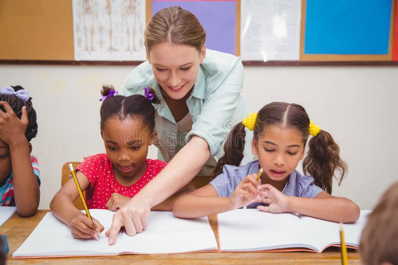 Pretty Teacher Helping Pupil in Classroom Stock Image - Image of ...