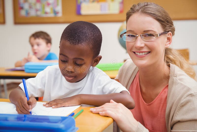 Pretty Teacher Helping Pupil in Classroom Stock Photo - Image of ...