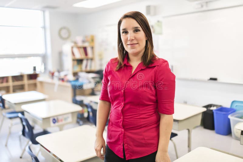 Pretty Teacher Smiling at Camera at Back of Classroom at the Elementary ...