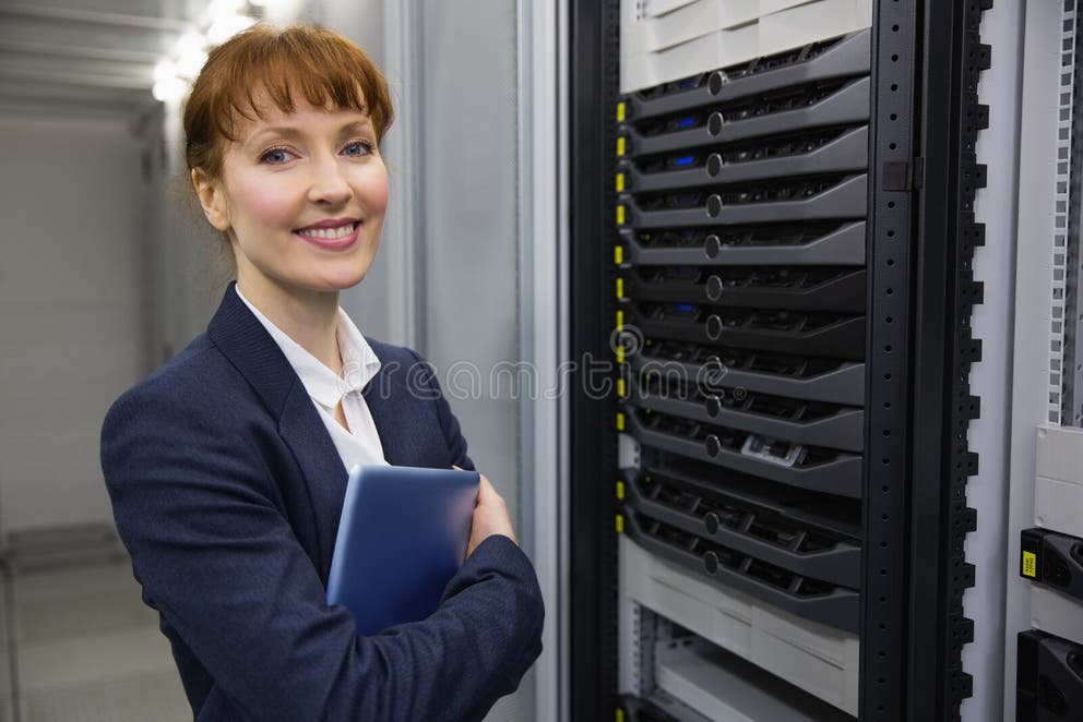 Pretty Technician Smiling at Camera beside Server Holding Tablet Pc ...