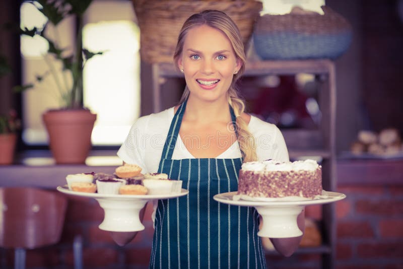 Pretty Waitress Holding a Chocolate Cake and Cupcakes Stock Photo ...