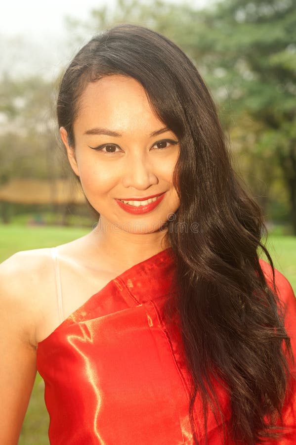 Pretty Woman in Red Thai Style Clothes Posing in the Park. Stock Image ...