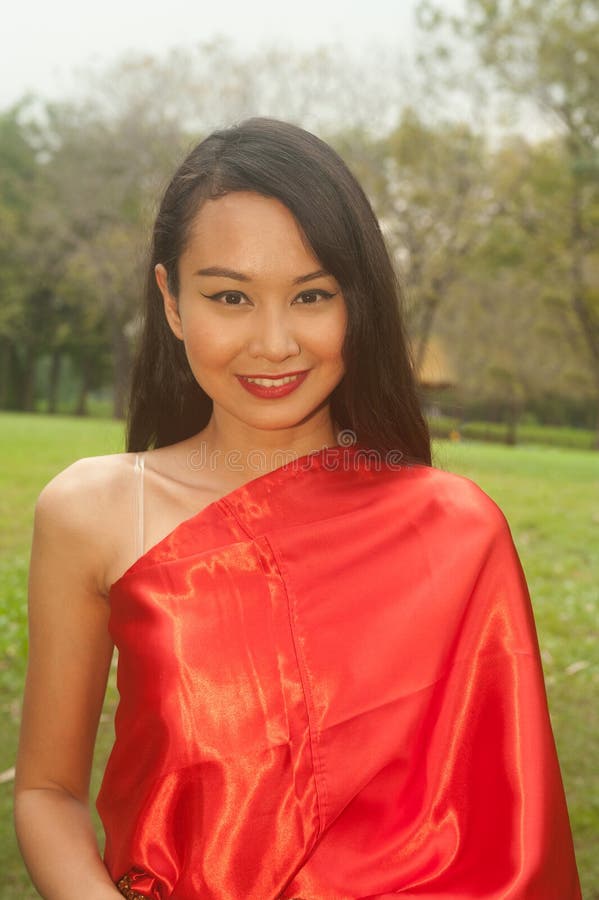 Pretty Woman in Red Thai Style Clothes Posing in the Park. Stock Image ...