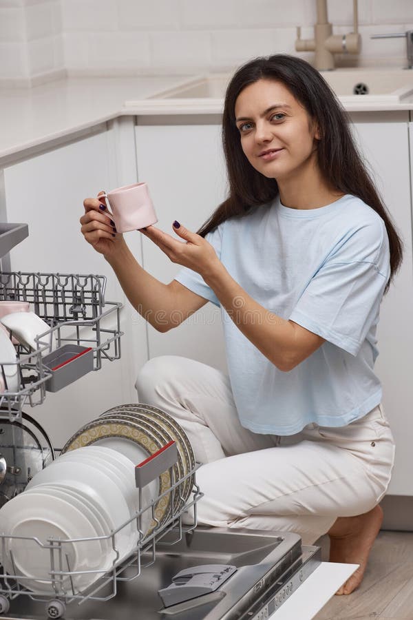 Pretty Woman Unloading from Open Dishwasher Machine with Clean Utensils ...